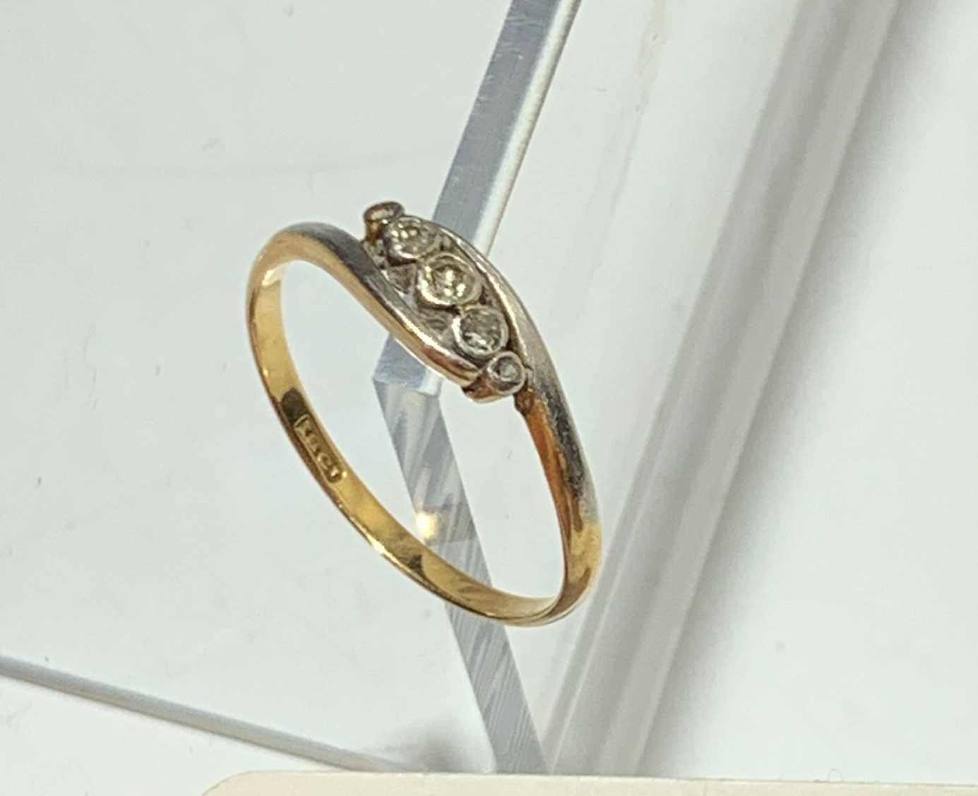 Lot 2553 - Three stone diamond cross over ring.