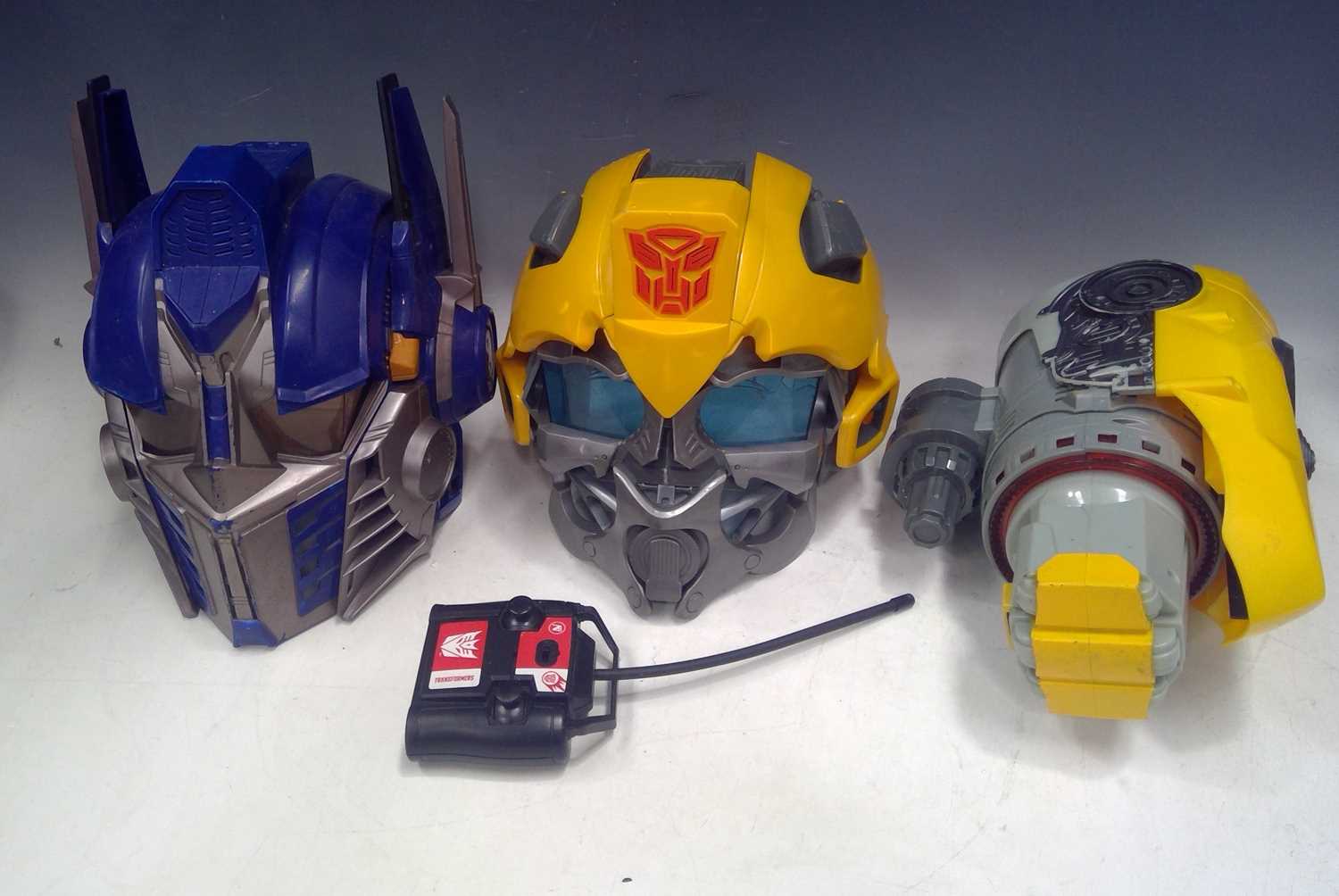 Lot 64 - Two Transformer Masks and a Robot Hand. The