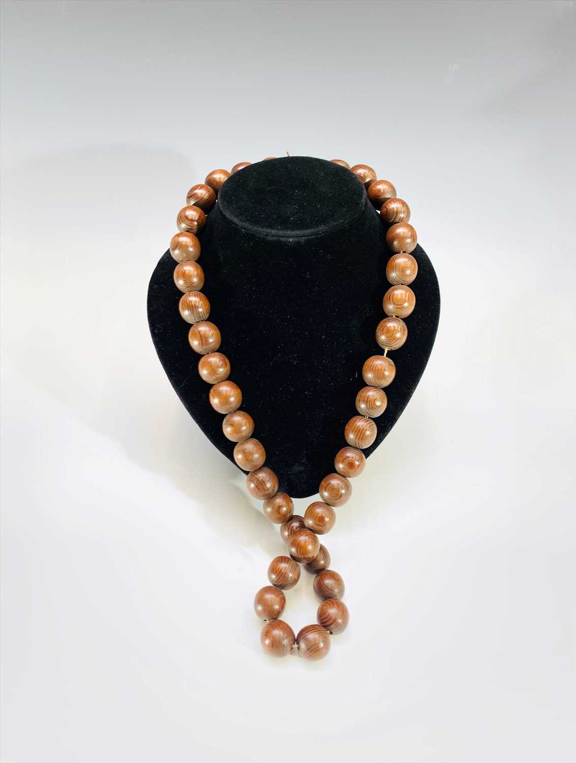 Lot 703 - A plain spherical pine bead necklace.