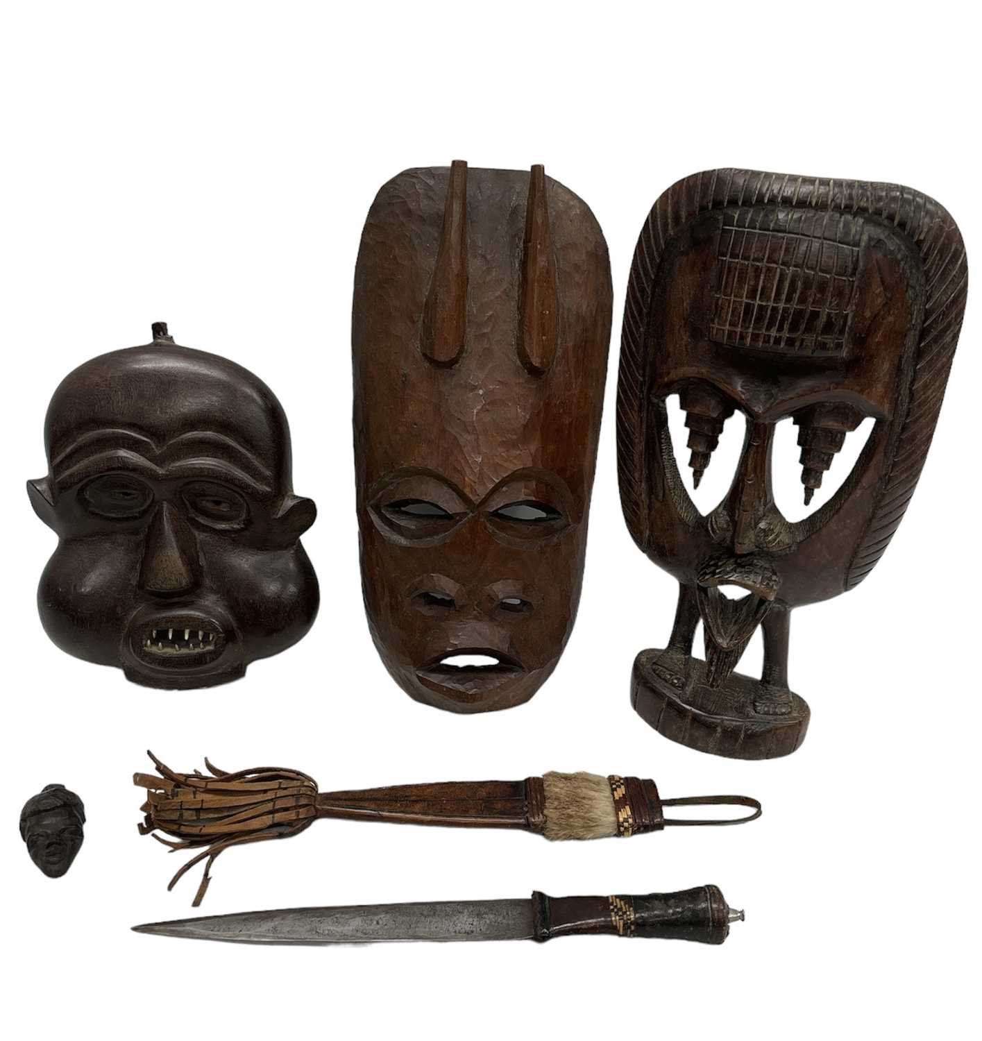 Lot 67 - Carved African masks and a dagger with sheath.