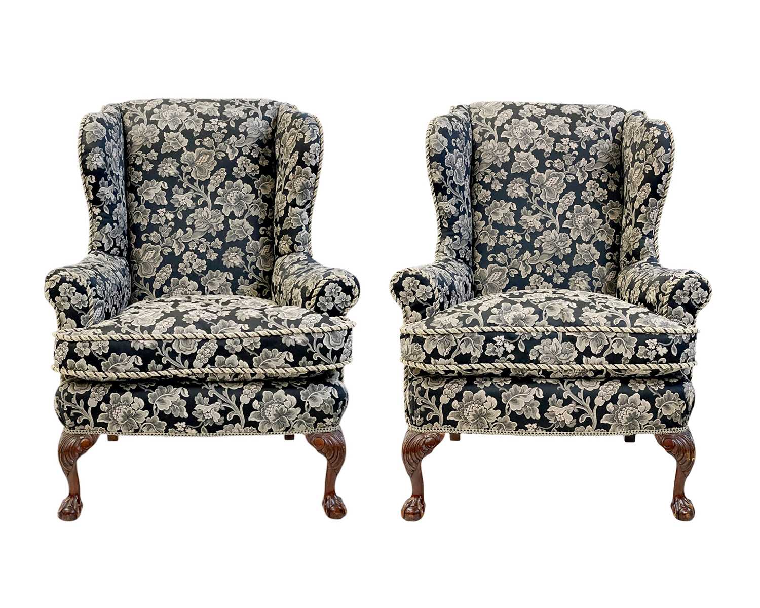 Lot 445 - A pair of upholstered wing back armchairs.