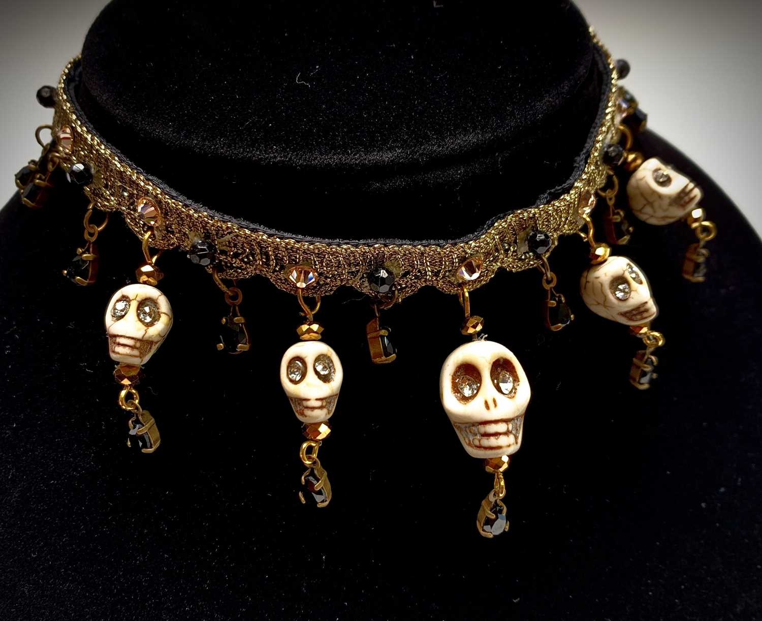 Lot 2303 - A choker macabre in golden lace strung with