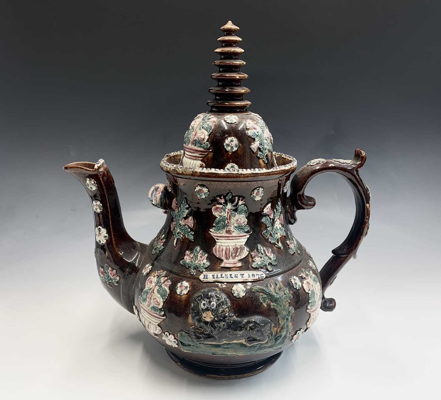 Lot 828 - A Measham treacle glazed barge ware teapot,
