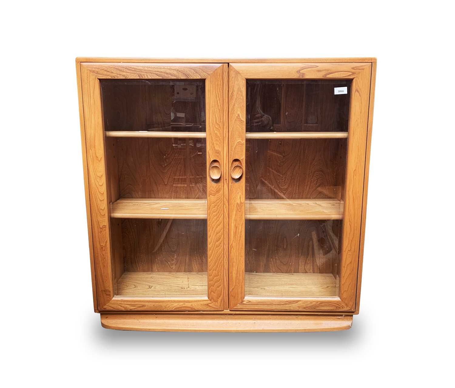 Lot 3065 - An Ercol light elm bookcase, with two