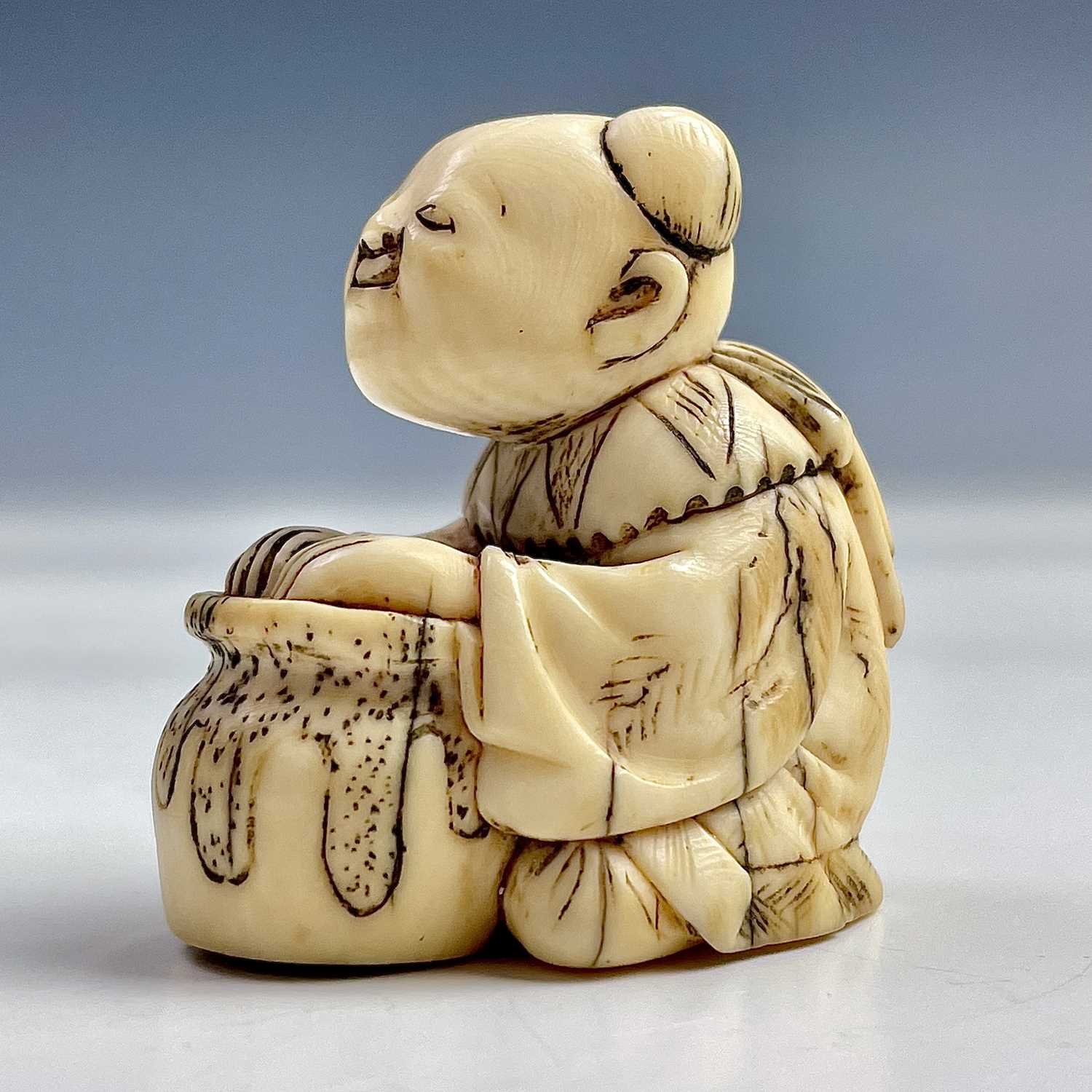 Lot 155 - A Japanese ivory netsuke of a seated man