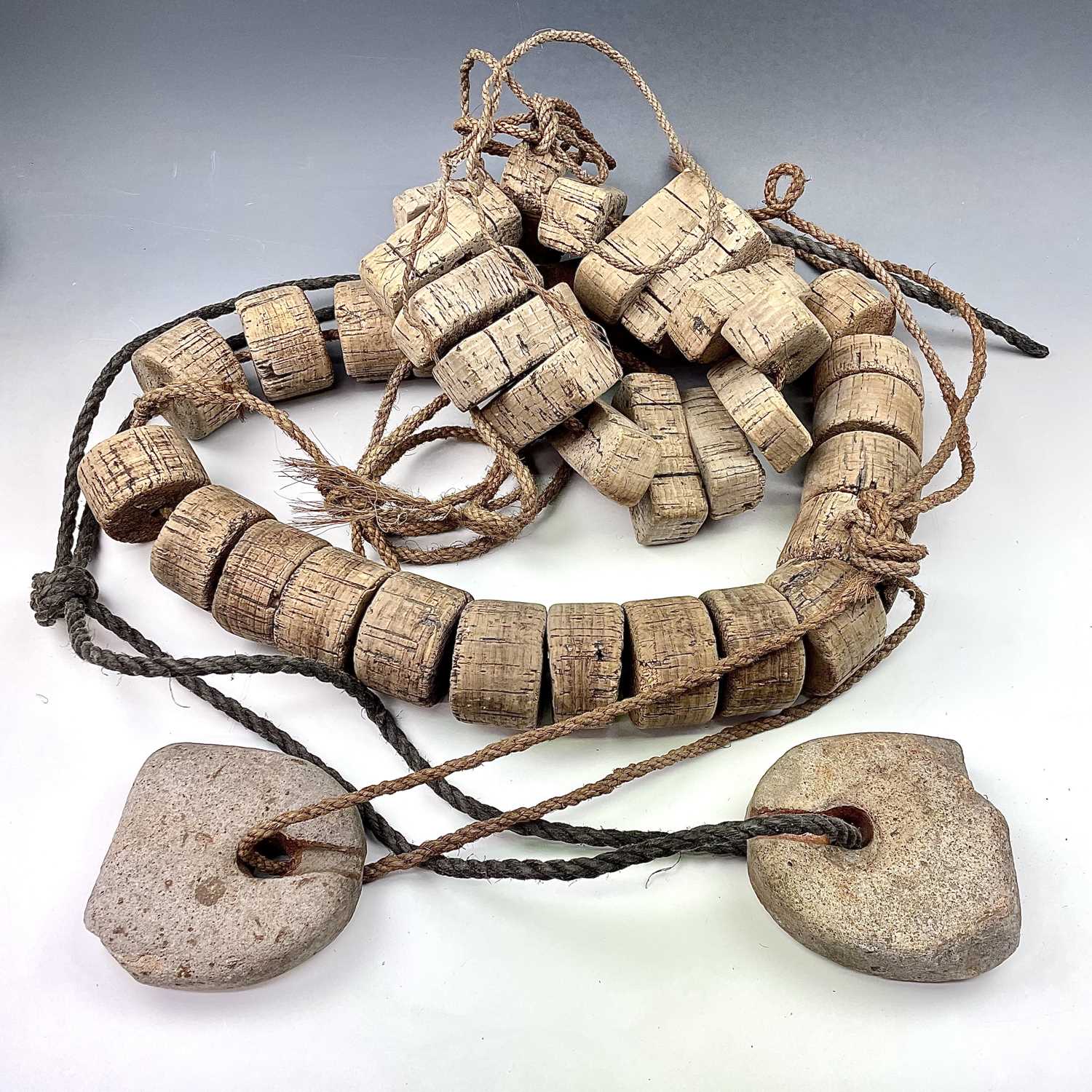 Lot 153 - Two strings of cork floats and stoneware end