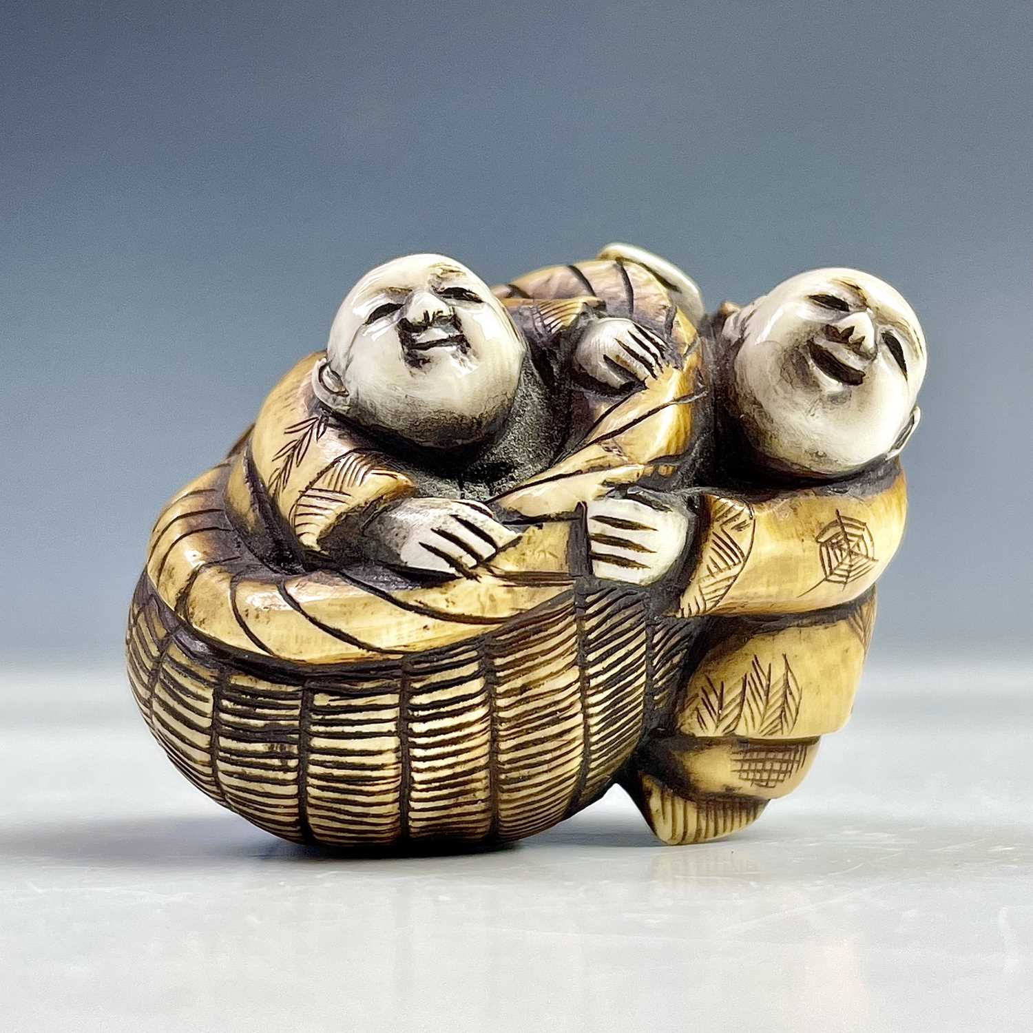 Lot 566 - A Japanese ivory netsuke of two figures and