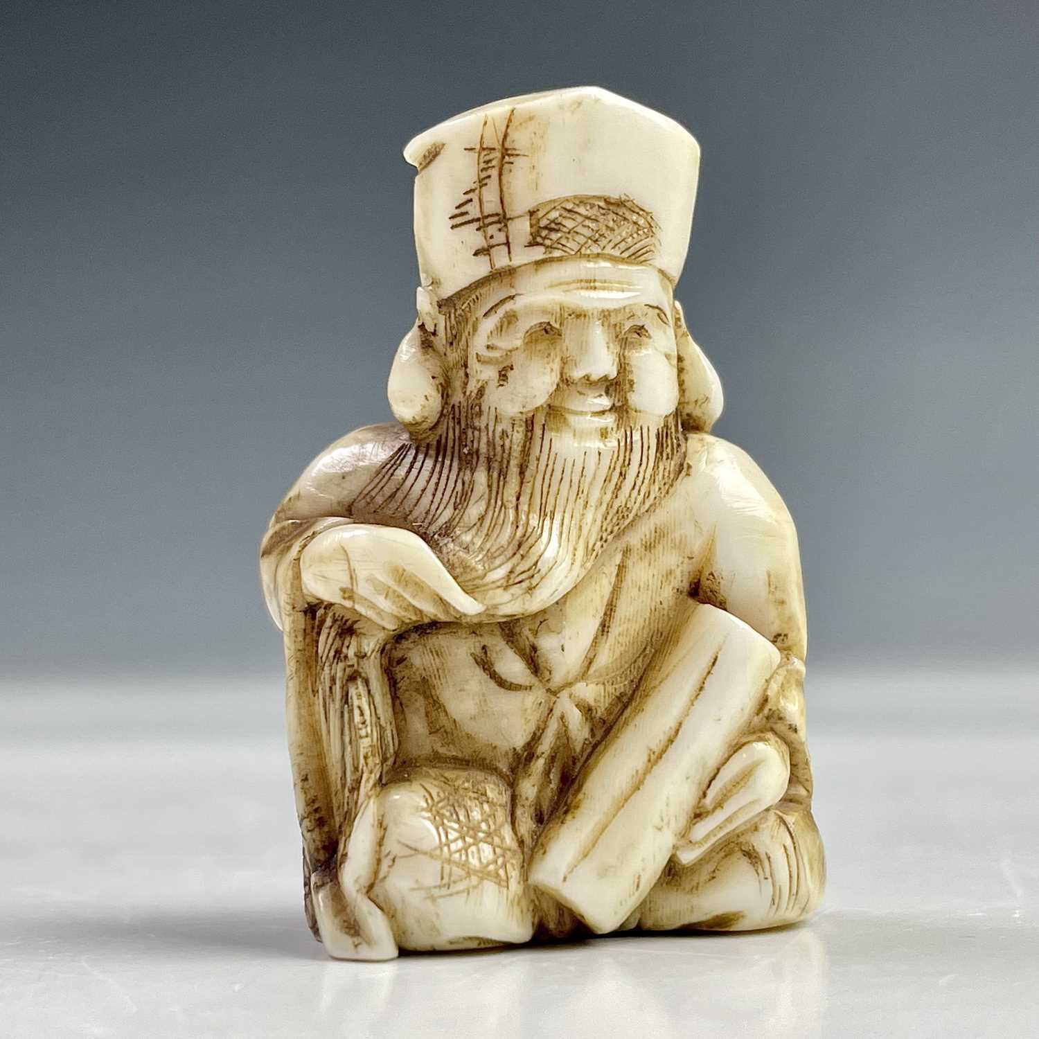 Lot 562 - A Japanese ivory netsuke of a seated bearded