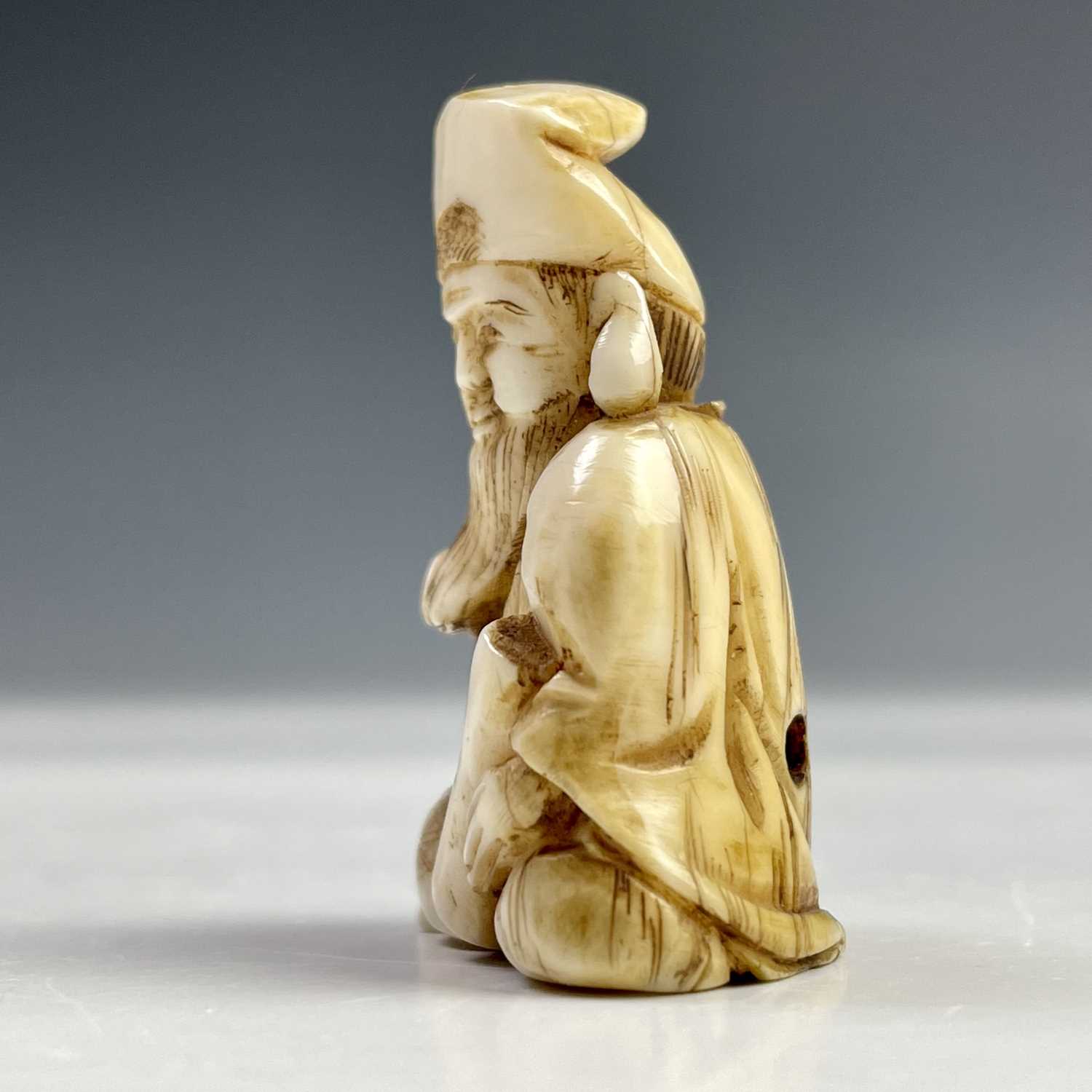 Lot 562 - A Japanese ivory netsuke of a seated bearded