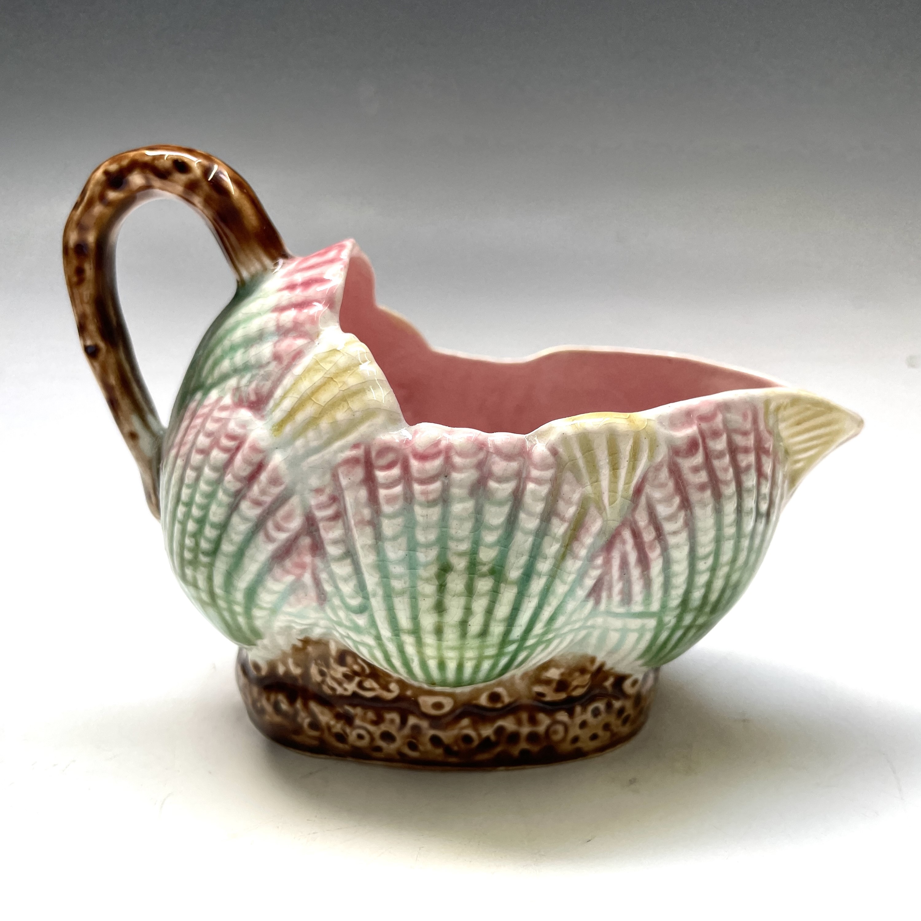 Lot 824 - A small green glazed majolica cream jug,