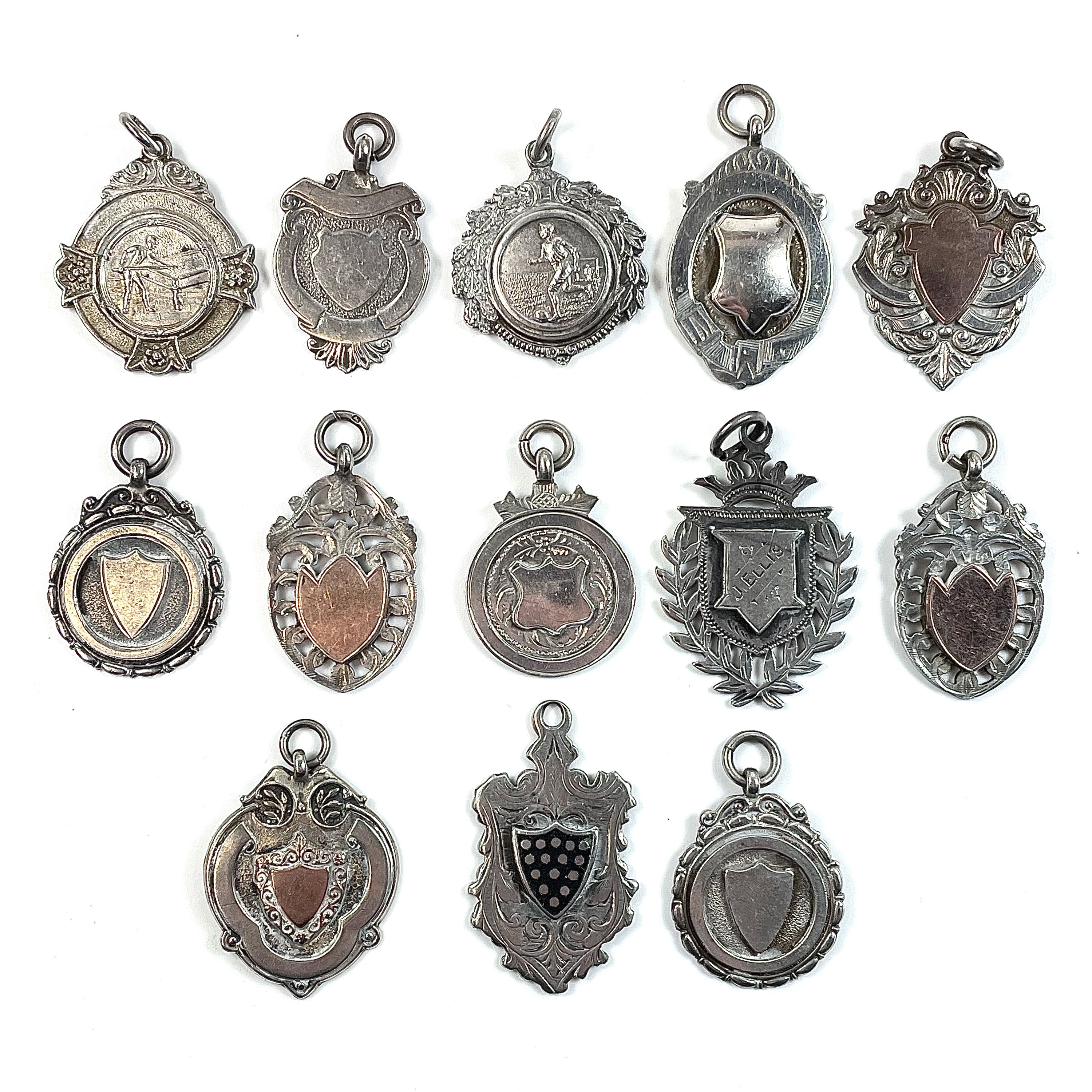 Lot 251 - A collection of thirteen silver shield fobs,