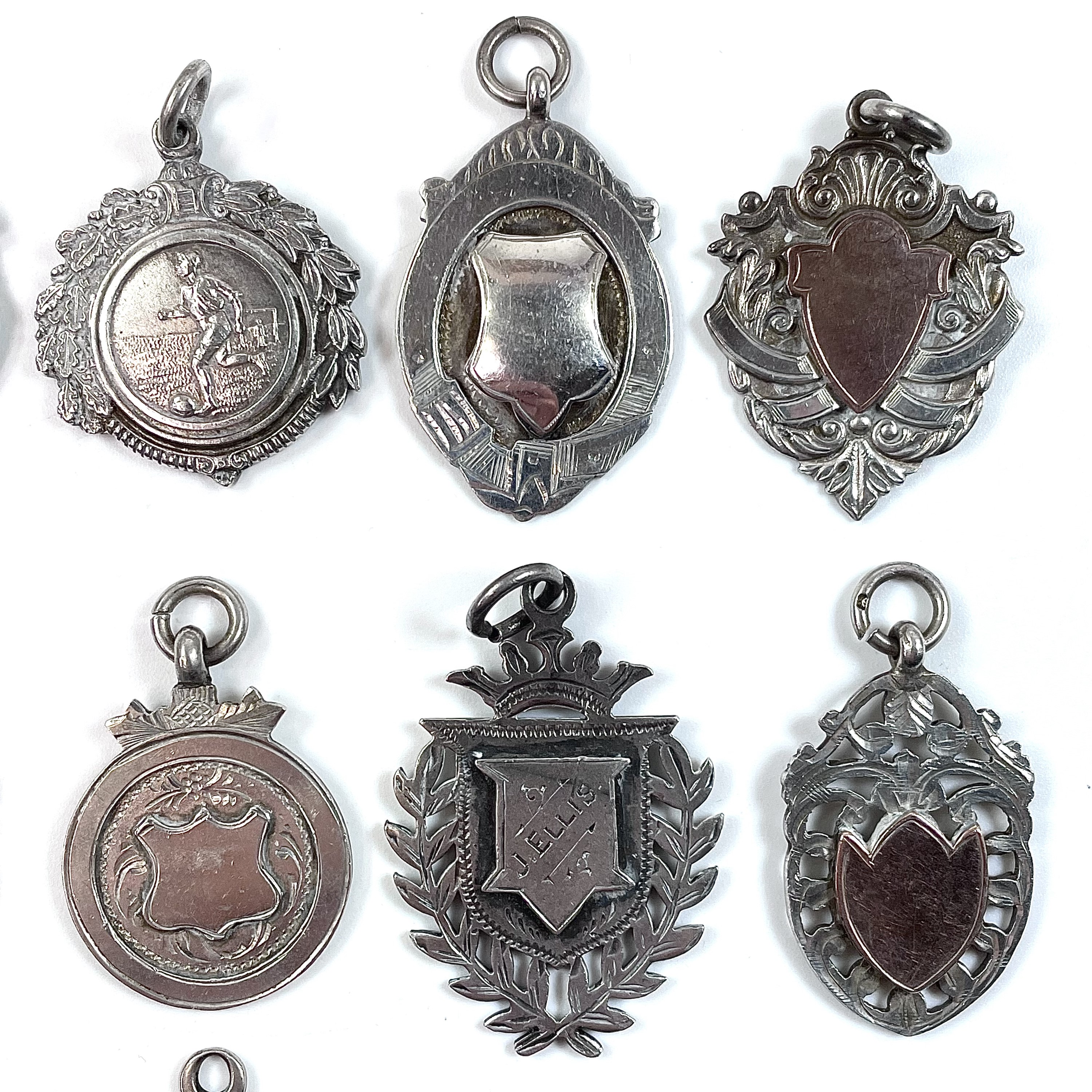 Lot 251 - A collection of thirteen silver shield fobs,