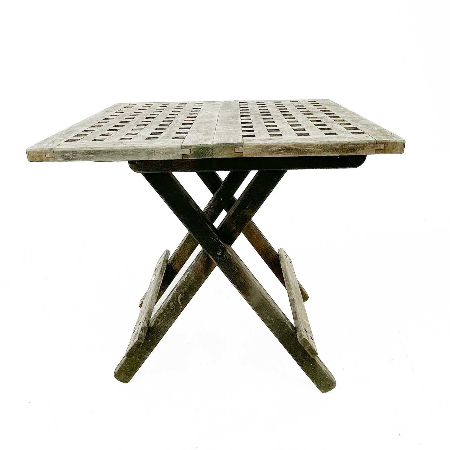 Lot 615 - A small teak folding table the top styled as