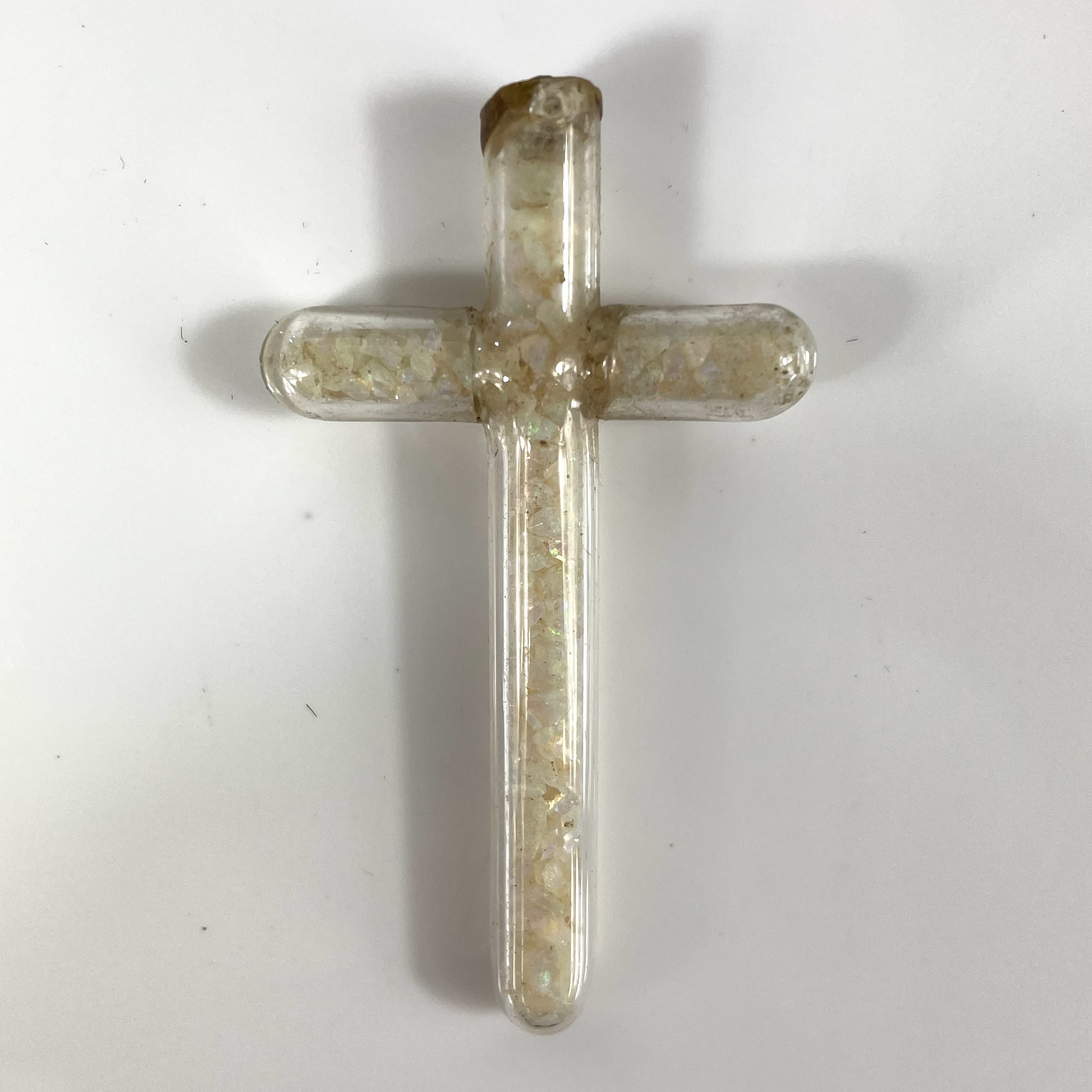 Lot 284 - A glass cross with white opal chips and hand